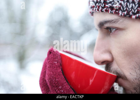 Man drinking hot tea in the winter park Stock Photo - Alamy