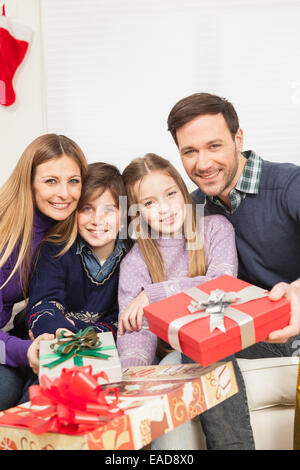 Family sitting together and Smiling with gifts on the occasion of ...