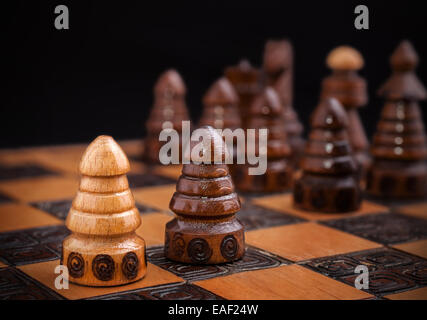 One pawn against all - wooden chess pieces on chessboard. Selective ...