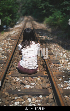 Beautiful girl sitting on railroad track Stock Photo: 116478581 - Alamy