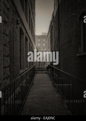 Concrete back alley with old fence near new lumber boards pickets at ...