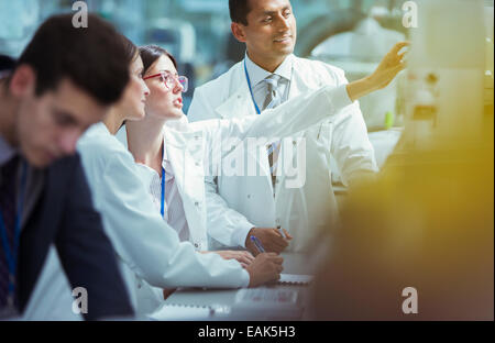 Young hispanic woman scientist writing on document working at ...