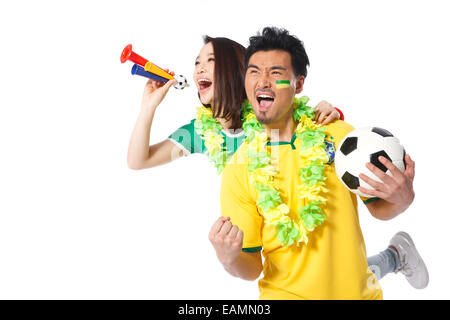 Excited fans with arm around cheering with Brazil Flag at sports event ...