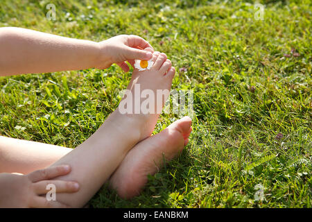Feet of small girl on grass with petals Stock Photo - Alamy
