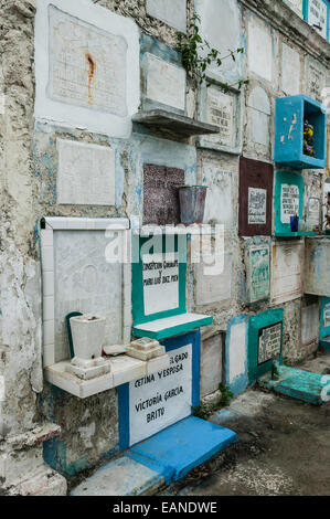 Colorful stacked graves with hand painted and carved grave markers, and ...