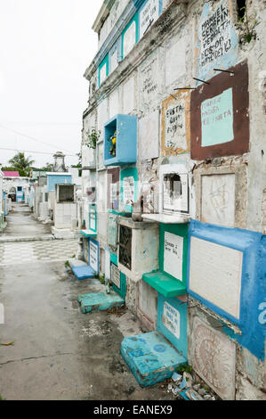 Colorful stacked graves with hand painted and carved grave markers, and ...