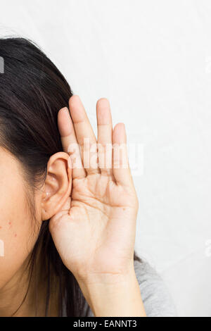 Listening man holds his hand near his ear on a blue background ...