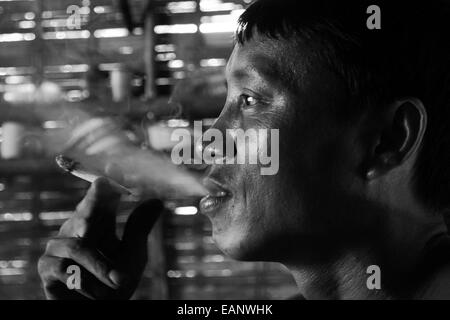 Lao man smoking a rolled cigarette Stock Photo - Alamy