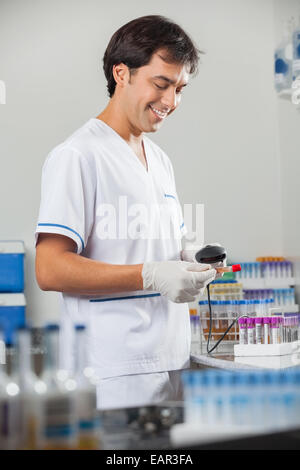 Laboratory technician scanning barcode of test tube with blood. Barcode ...