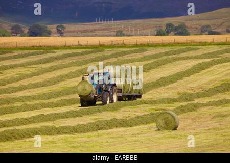 Tractor and trailer transporting hay bails below radar station. Great ...
