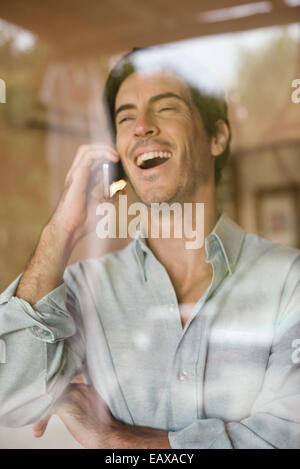 Carefree man talking on phone call using smartphone while wearing ...
