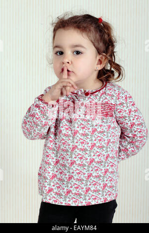 Cute little girl showing silence gesture on white background Stock ...