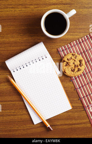 Opened notepad and cup of coffee with chocolate cookies on vintage ...