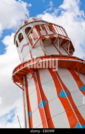 The colorful, tall structure of a Helter Skelter slide at a funfair or ...