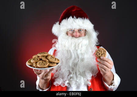 A hand holding a Santa Claus chocolate candy with a Christmas tree in ...