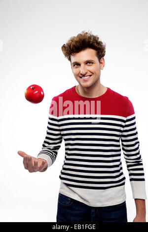 Portrait of handsome man throwing apple in the air Stock Photo - Alamy