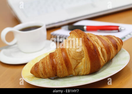 Butter croissant and coffee on office desk Stock Photo - Alamy