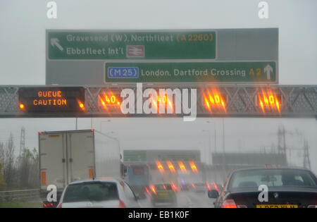 Speed limits and Queue warning signs light up during pouring rain over ...