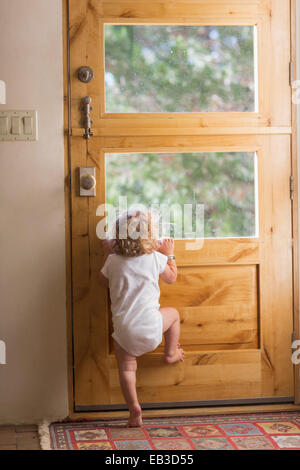 Boy climbing out of window Stock Photo - Alamy