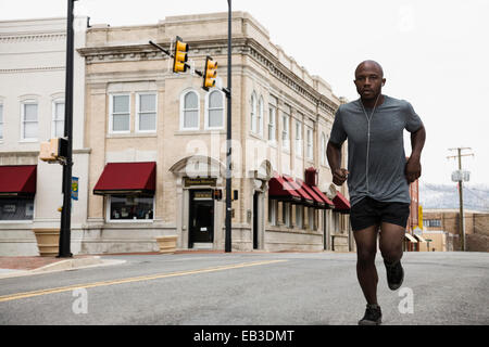 Black man running on street in neighborhood Stock Photo - Alamy