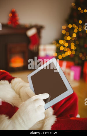 Father christmas touching tablet pc at home in the living room Stock ...
