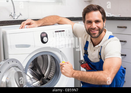 happy man fixing a washing machine Stock Photo - Alamy