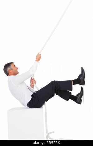 Businessman sitting on rope Stock Photo - Alamy