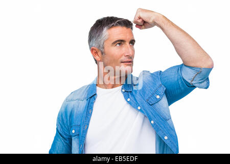 Man with grey hair tensing arm muscle Stock Photo - Alamy