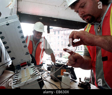 Workers splice fiber optic cables in a mobile fiber optic splicing ...