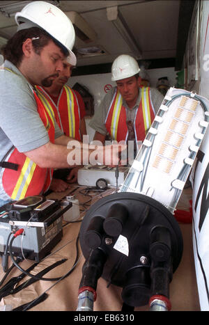 Workers splice fiber optic cables in a mobile fiber optic splicing ...