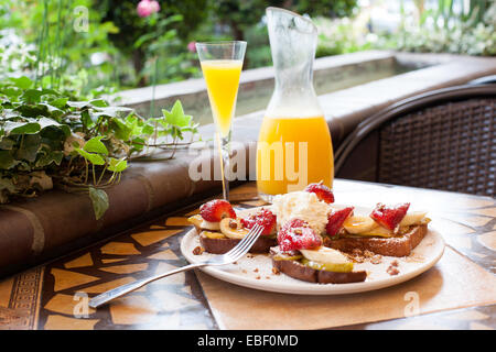 French toast and mimosa at brunch in garden patio setting Stock Photo ...