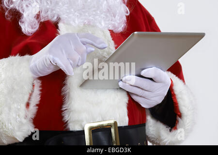 Tablet on Christmas background with santa hat and gift box. New Year ...