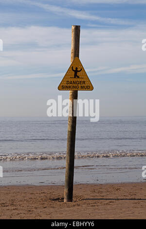 Warning sign about the danger of sinking sands on the mudflats at ...
