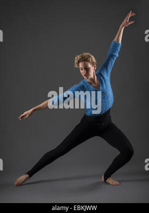 Female ballet dancer with arms outstretched leaning back, looking up ...