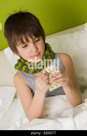Sick boy taking tablets Stock Photo - Alamy