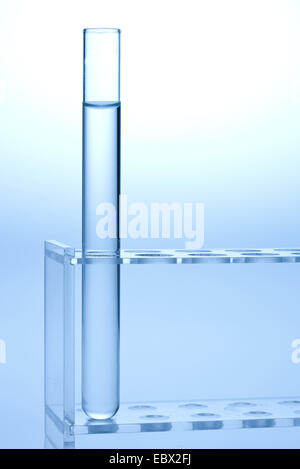 single test tube with colourless liquid standing in a test tube rack, a ...