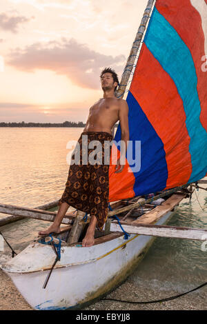 Young man in out rigger boat in Indonesia Stock Photo - Alamy