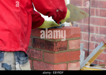 Bricklaying checking brick is level Stock Photo - Alamy