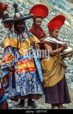 Monks wearing gonchas and red hats play cymbals and drums while a monk ...
