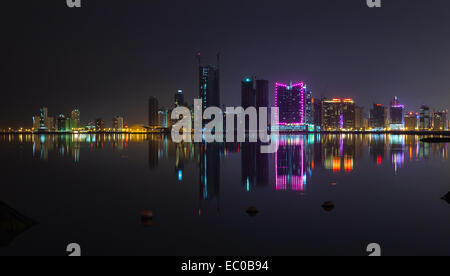 Night modern city skyline with shining neon lights and reflection in ...