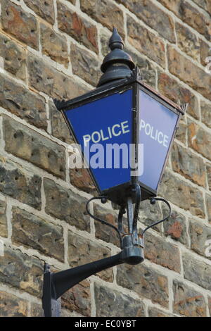 Old fashioned vintage police sign on a globe light hangs on a brick ...