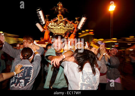 Festival participants carry "Omikoshi" - a portable Shinto shrine which ...