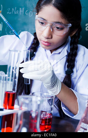 Teenager girl working at scientist laboratory holding degree pointing ...