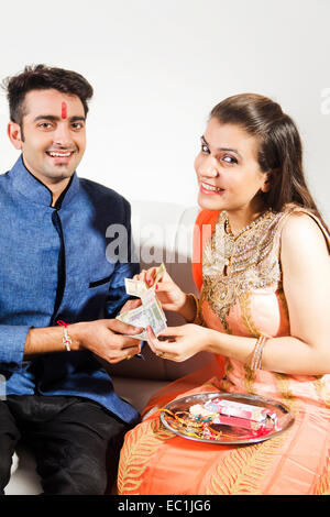 Surprised man holding money, looking amazed at camera, touching chest ...