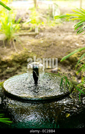 Water flow down into the large jar. Making of waterfall for garden ...