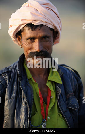 Camel shepherd make a neckless to camel Stock Photo - Alamy