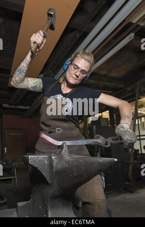female blacksmith working at ambos with hammer on redhot steel Stock ...