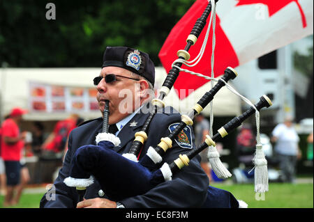 A police bagpiper plays during Canada Day Celebrations held in London ...