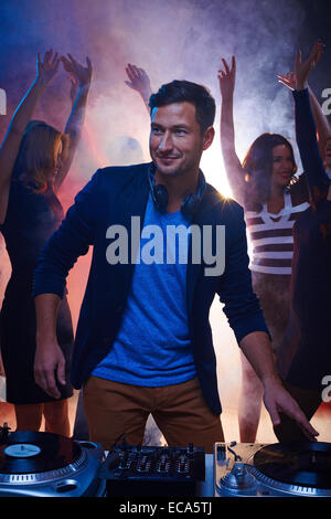 Male deejay and dancing friends enjoying night party Stock Photo - Alamy