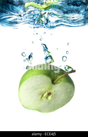 green apple dropped into water with bubbles isolated on white Stock ...